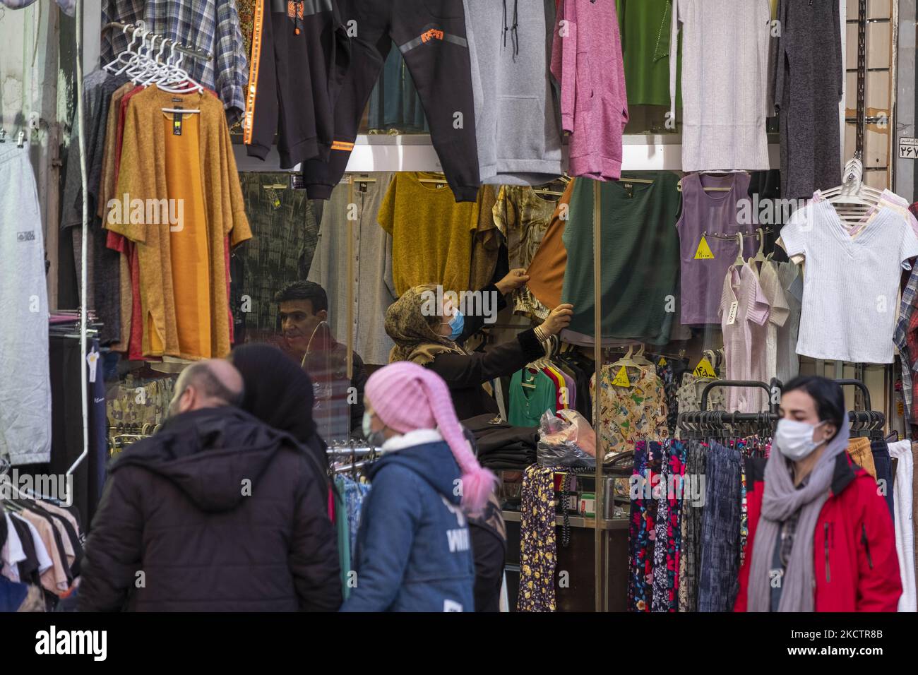 An Iranian woman looks on clothes while shopping at a shop in downtown ...