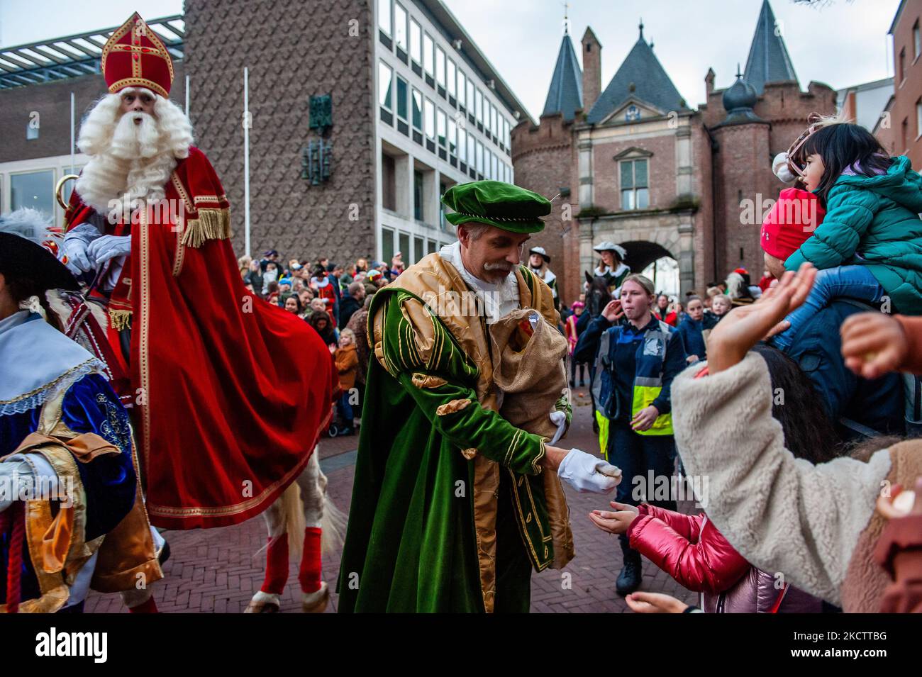 St. Nicholas is arriving to the city riding his white horse and ...