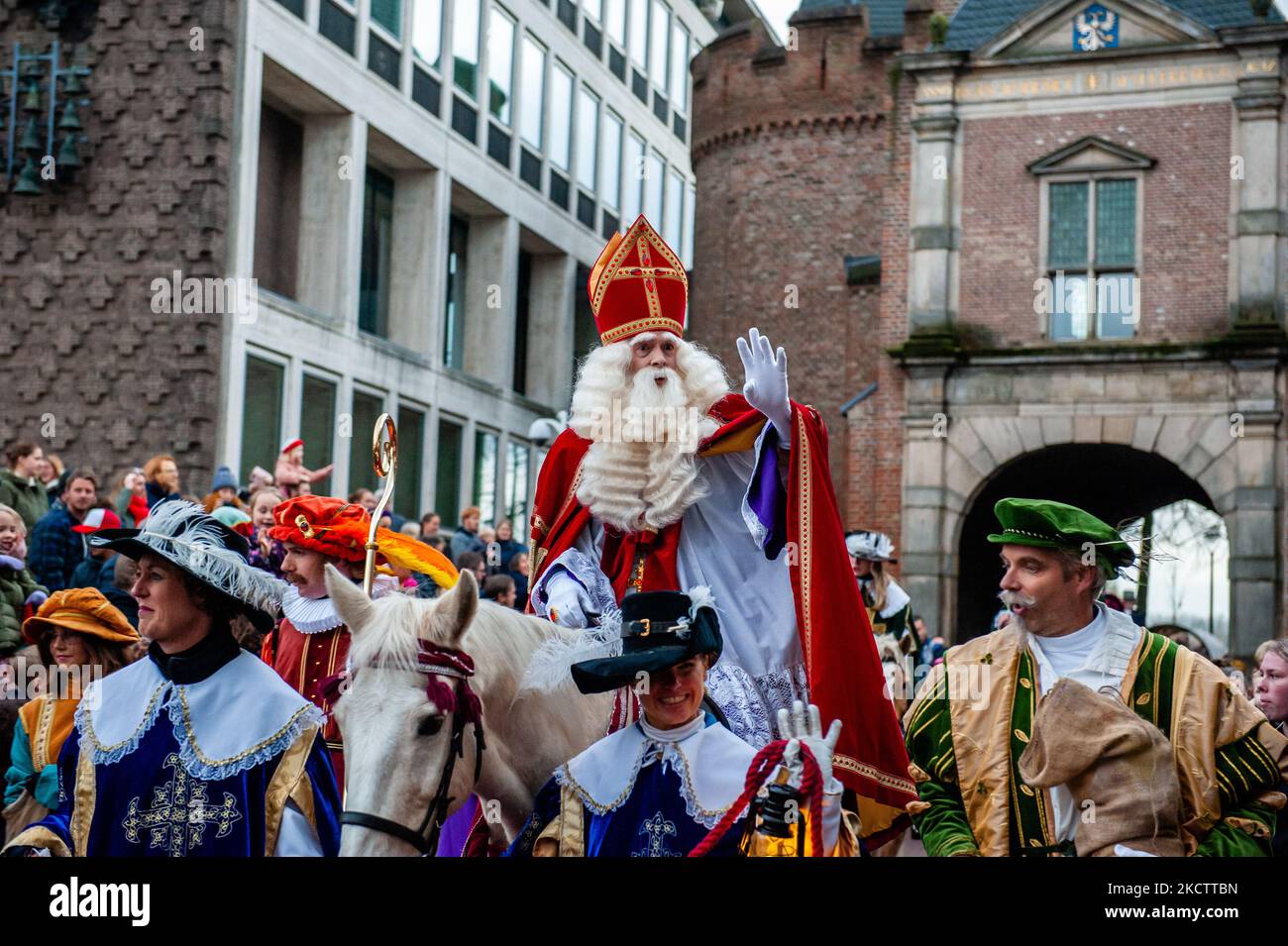St. Nicholas is arriving to the city riding his white horse and ...