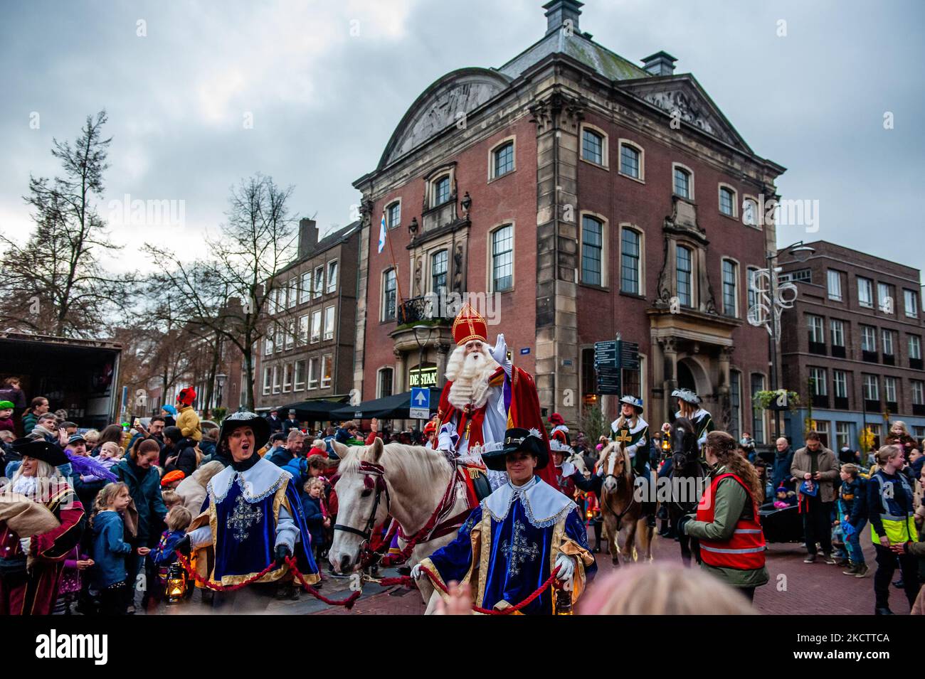St. Nicholas is arriving to the city riding his white horse and ...