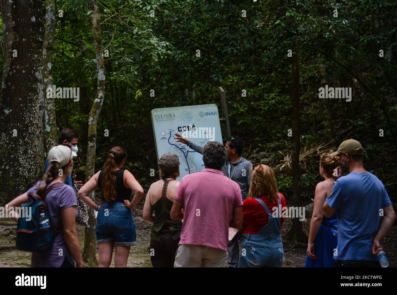 A group of visitors listen to the guide's explanations at the entrance ...