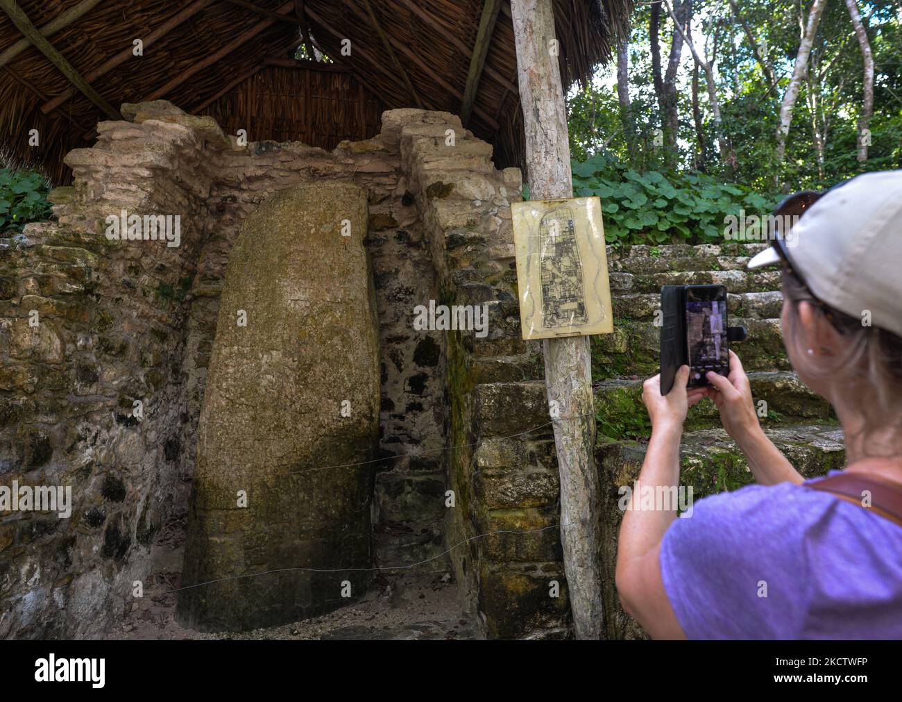 A visitor takes a photo of a stele, large stone slabs containing ...