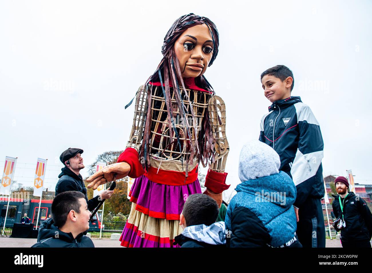 A group of children is receiving the giant puppet 'Little Amal', a nine ...