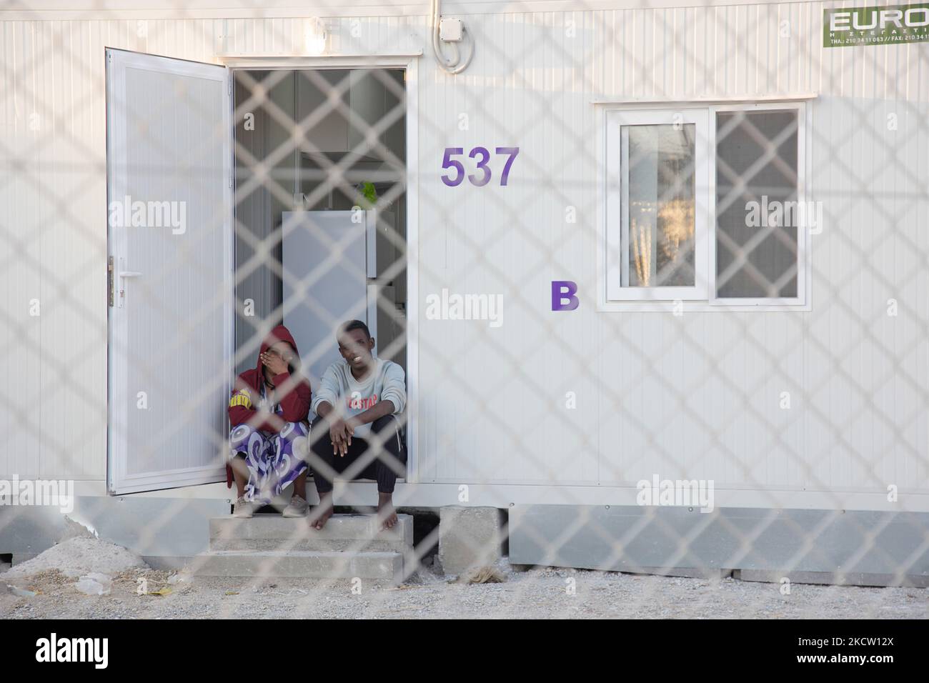 Asylum seekers outside their housing facility during the evening ...