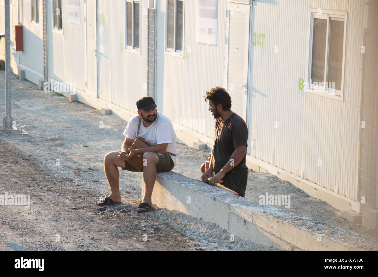 Asylum seekers outside their housing facility during the evening ...