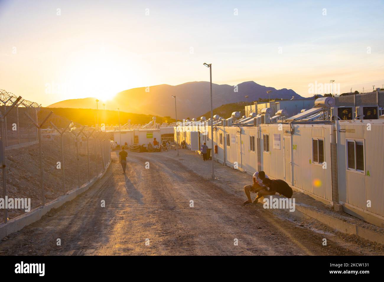 Asylum seekers outside their housing facility during the evening ...