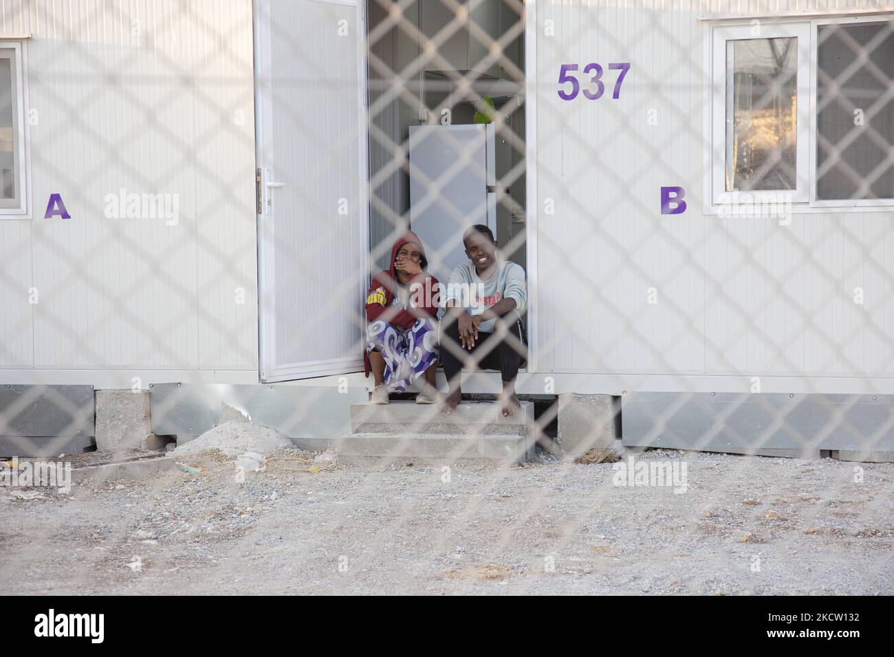 Asylum seekers outside their housing facility during the evening ...