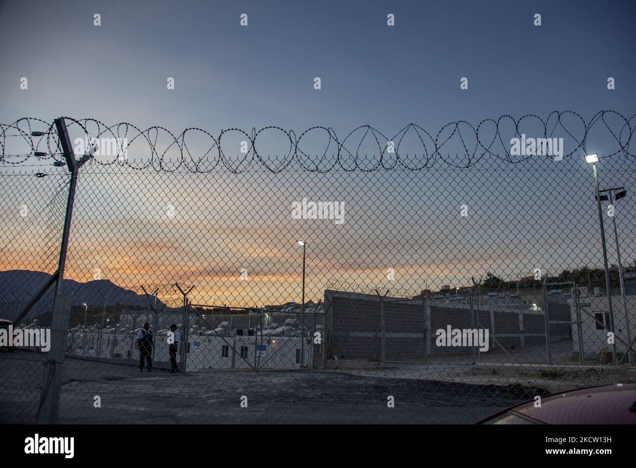 Barbed-wire fence protecting the camp from outsiders. Evening sunset ...