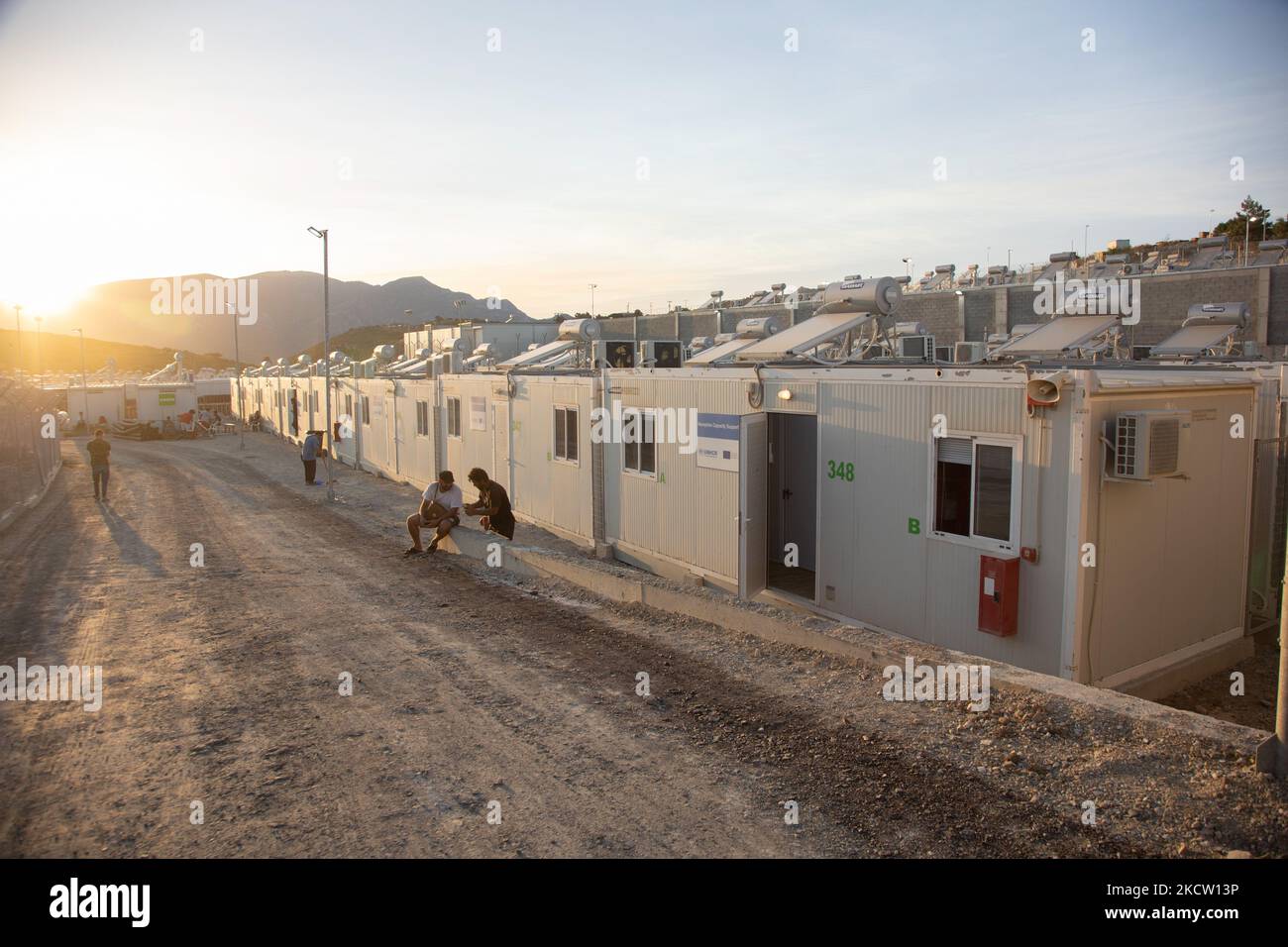 Asylum seekers outside their housing facility during the evening ...