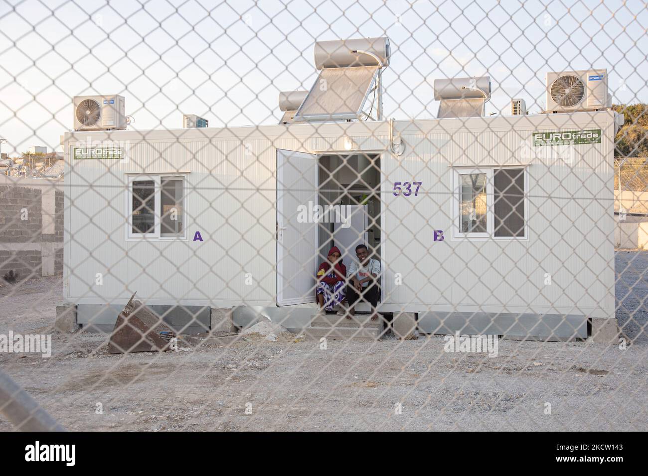 Asylum seekers outside their housing facility during the evening ...