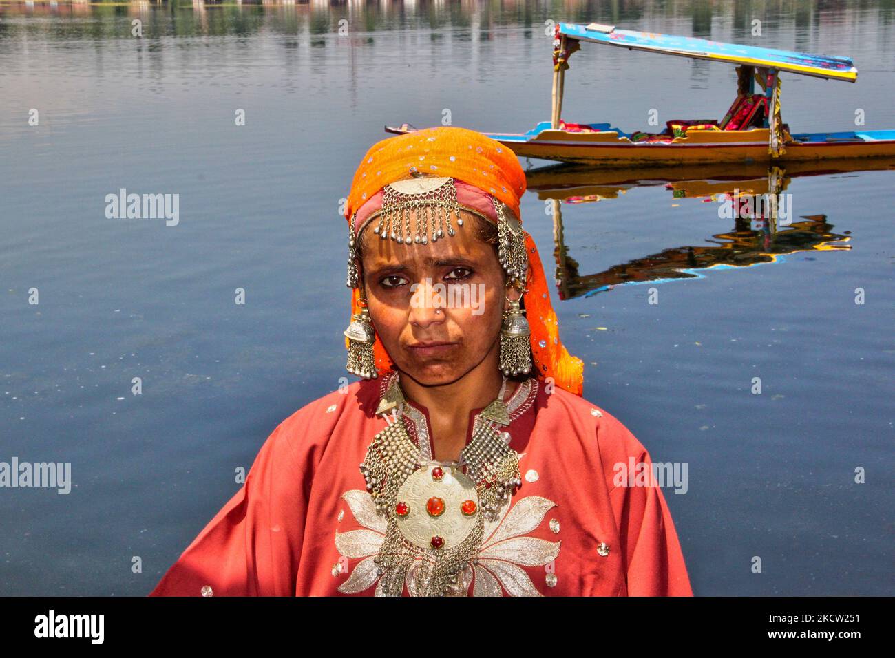 Kashmiri Muslim woman dressed in traditional finery with Dal Lake seen ...
