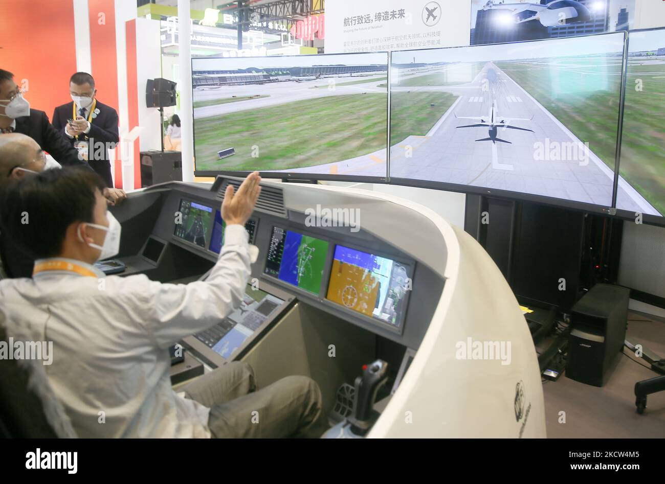 Shanghai. 5th Nov, 2022. A staff member instructs as a visitor tries a ...