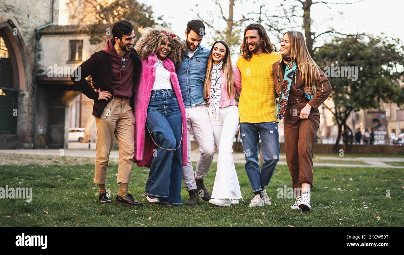 Happy multi-ethnic best friends hugging walking on the grass - joyful ...