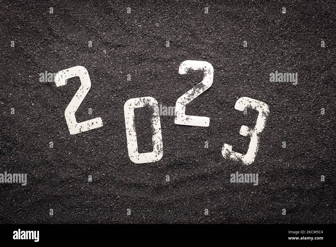 Happy New Year 2023 concept with a shell and a starfish on black beach ...