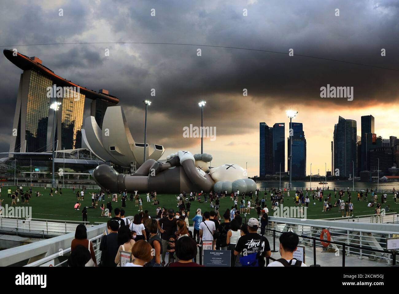 People gather to view the "KAWS:HOLIDAY" art installation featuring a ...