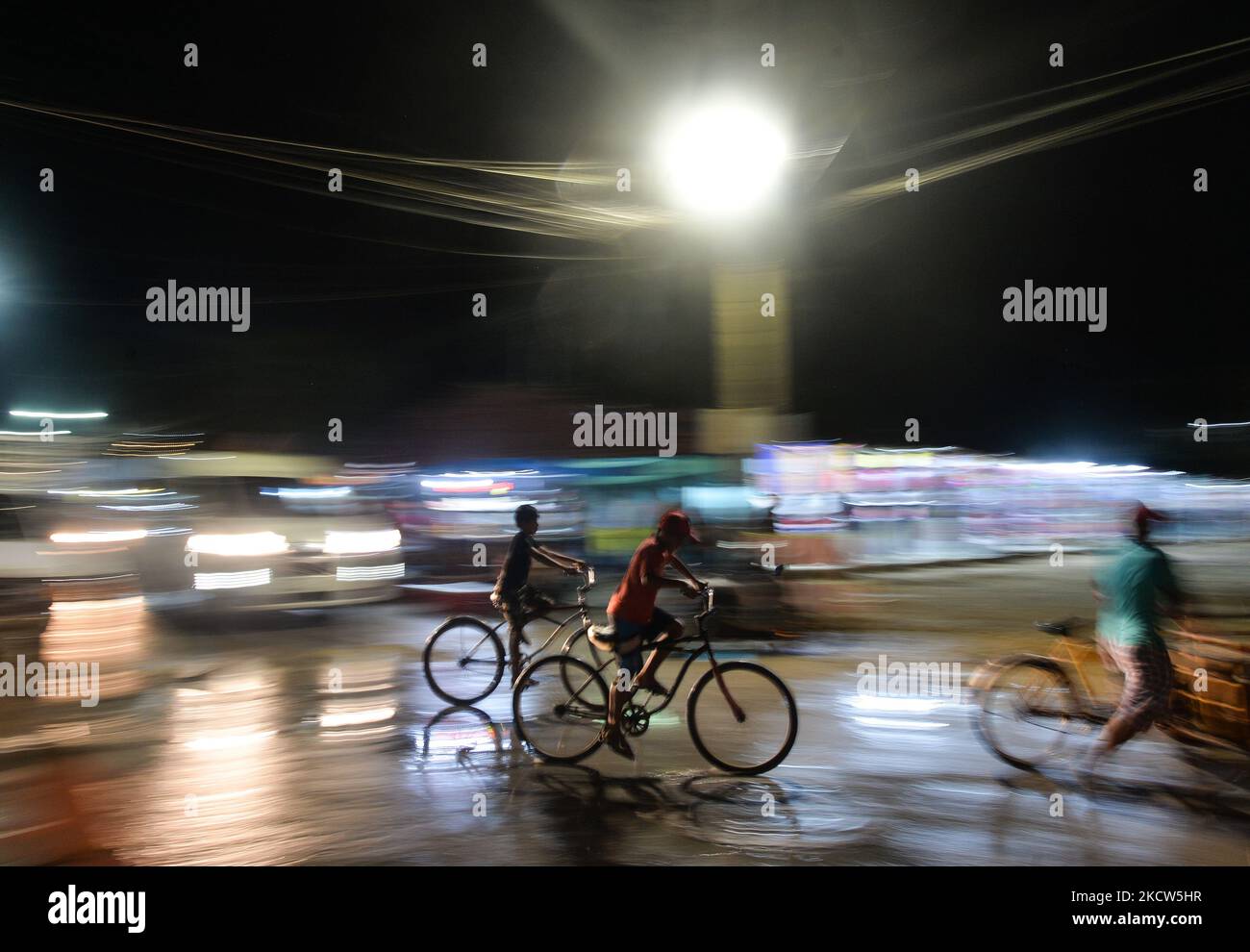 Young kids cycling during a rain in Tulum center. On Sunday, November ...