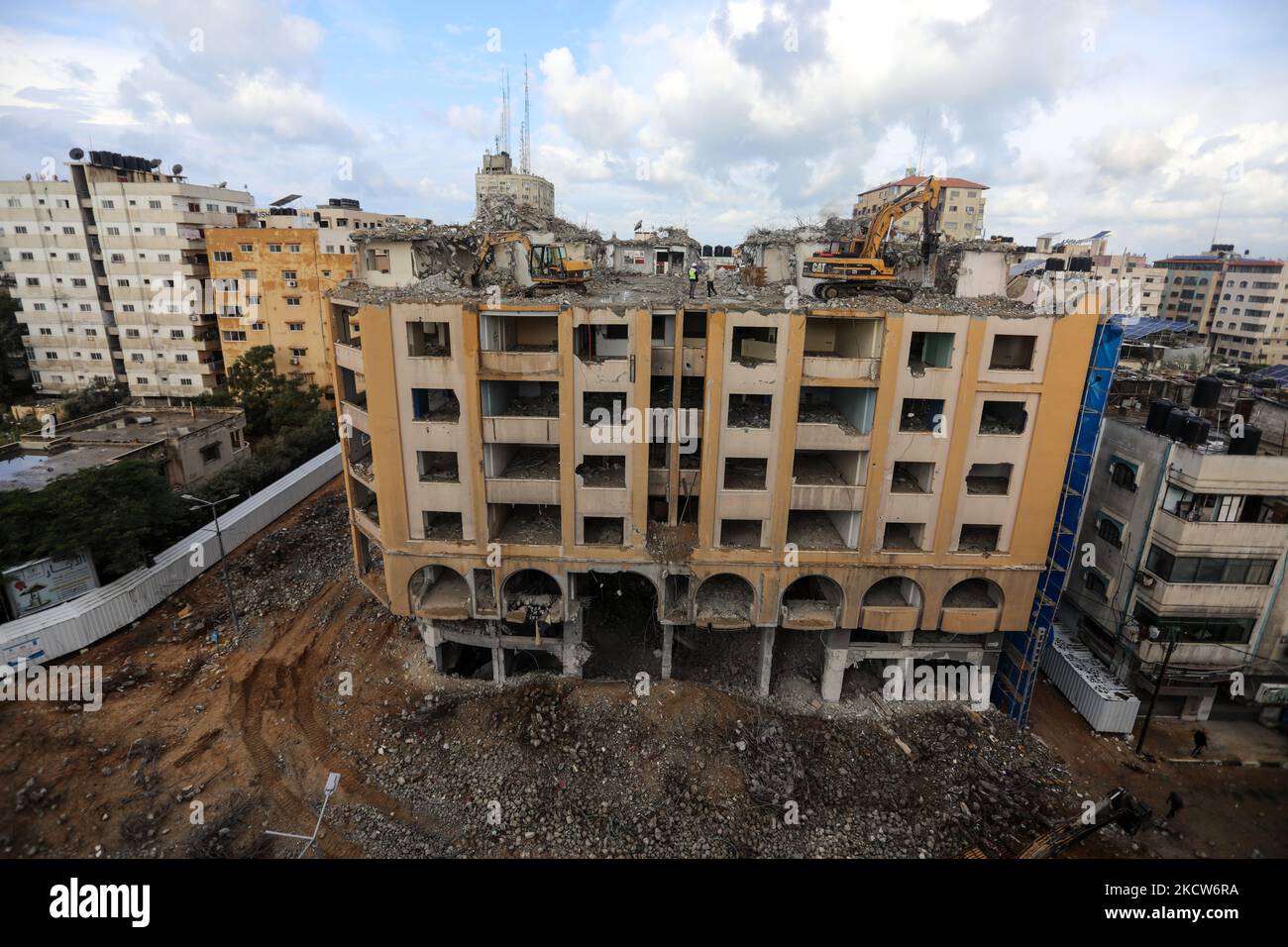 Palestinian workers clear the rubble of Al-Jawhara Tower building that ...