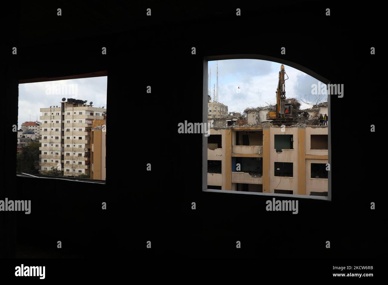 Palestinian workers clear the rubble of Al-Jawhara Tower building that ...