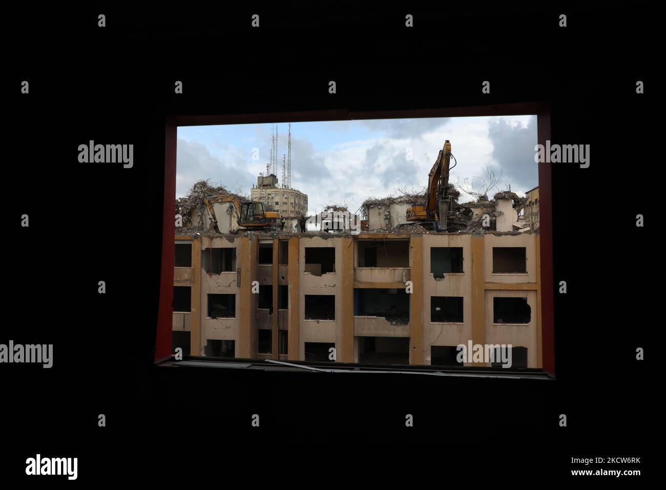 Palestinian workers clear the rubble of Al-Jawhara Tower building that ...