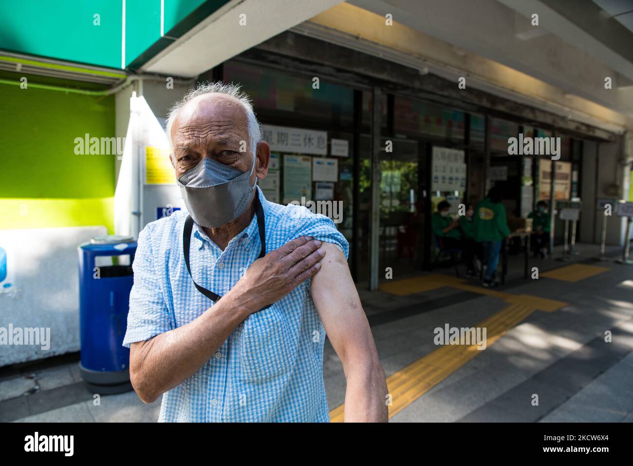 An 84-year old resident proudly displays his injection with the third ...