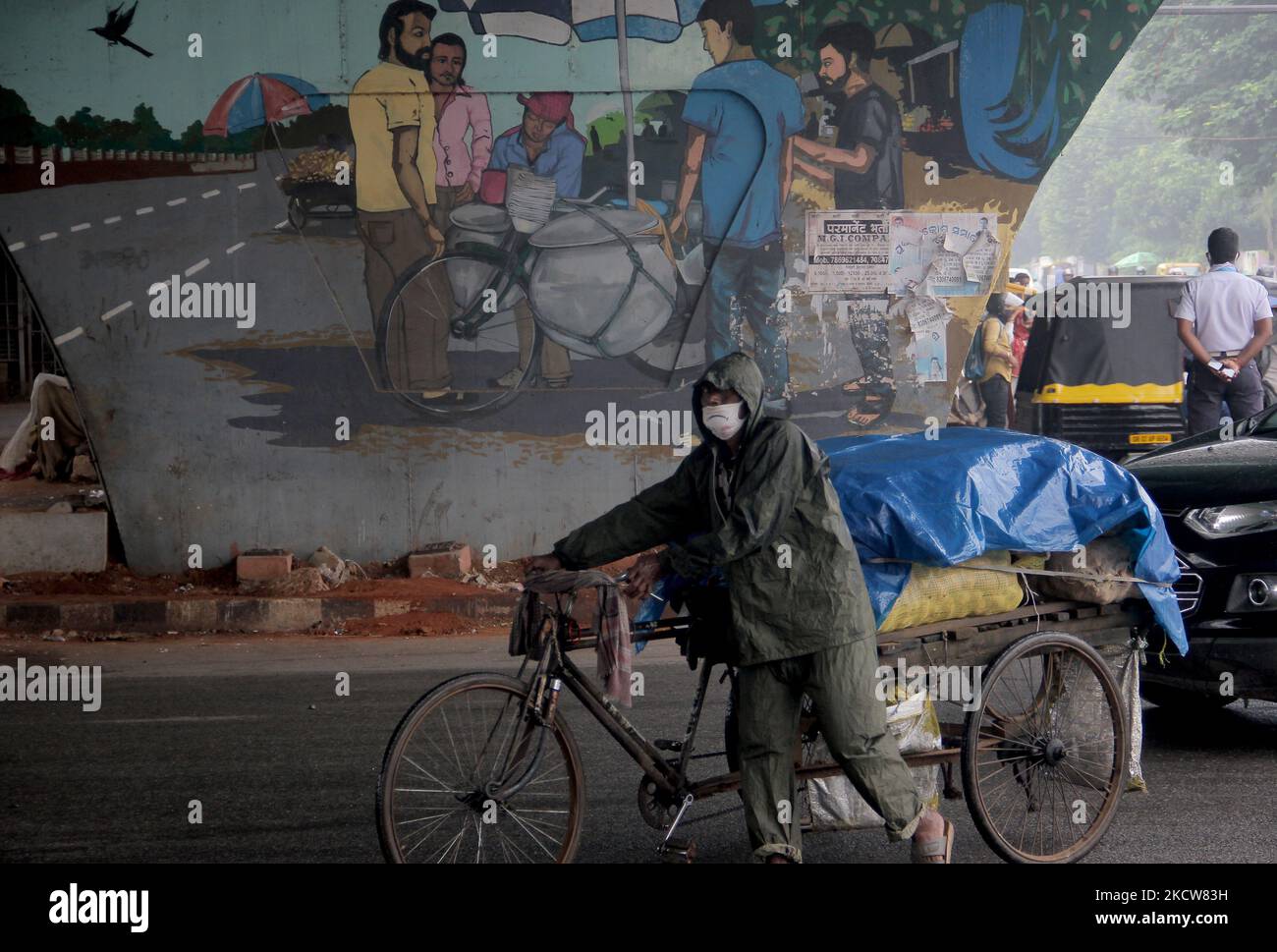 A trolley rickshaw puller wears protective mask as he is seen at the ...