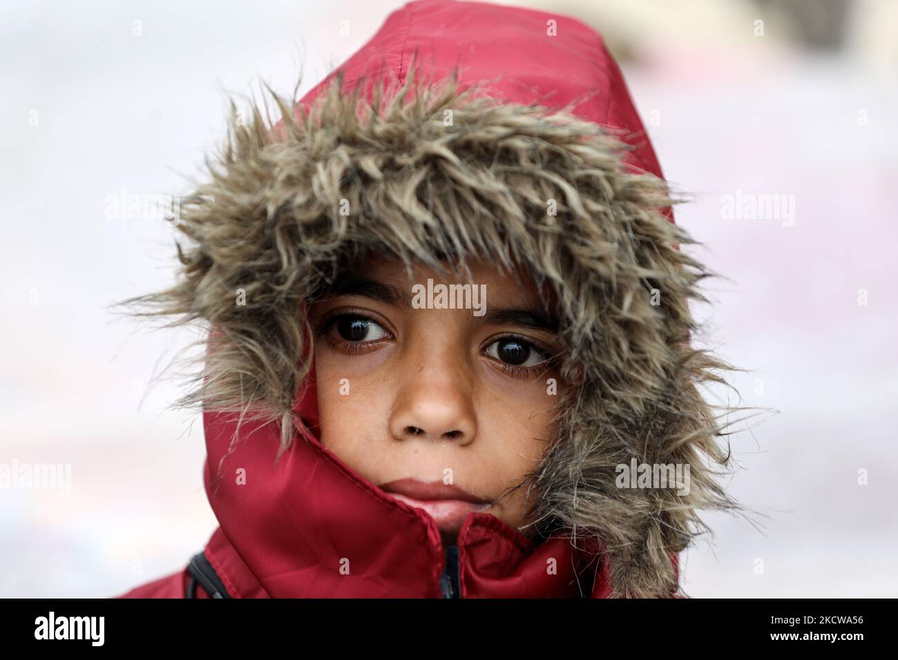 A Palestinian boy walks in the street during rainy weather in Gaza City ...