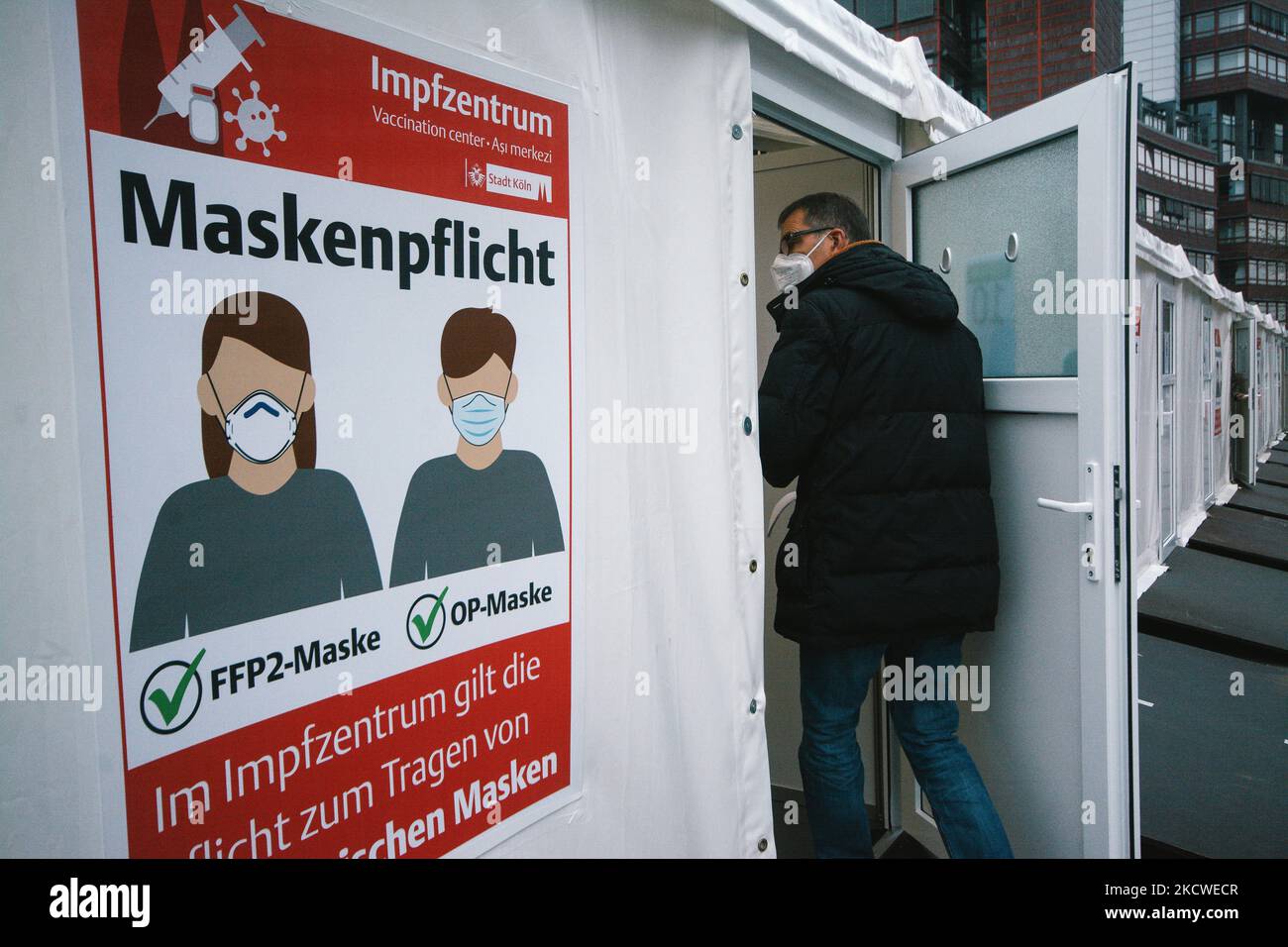A man with face mask is seen walking into a vaccination station at ...