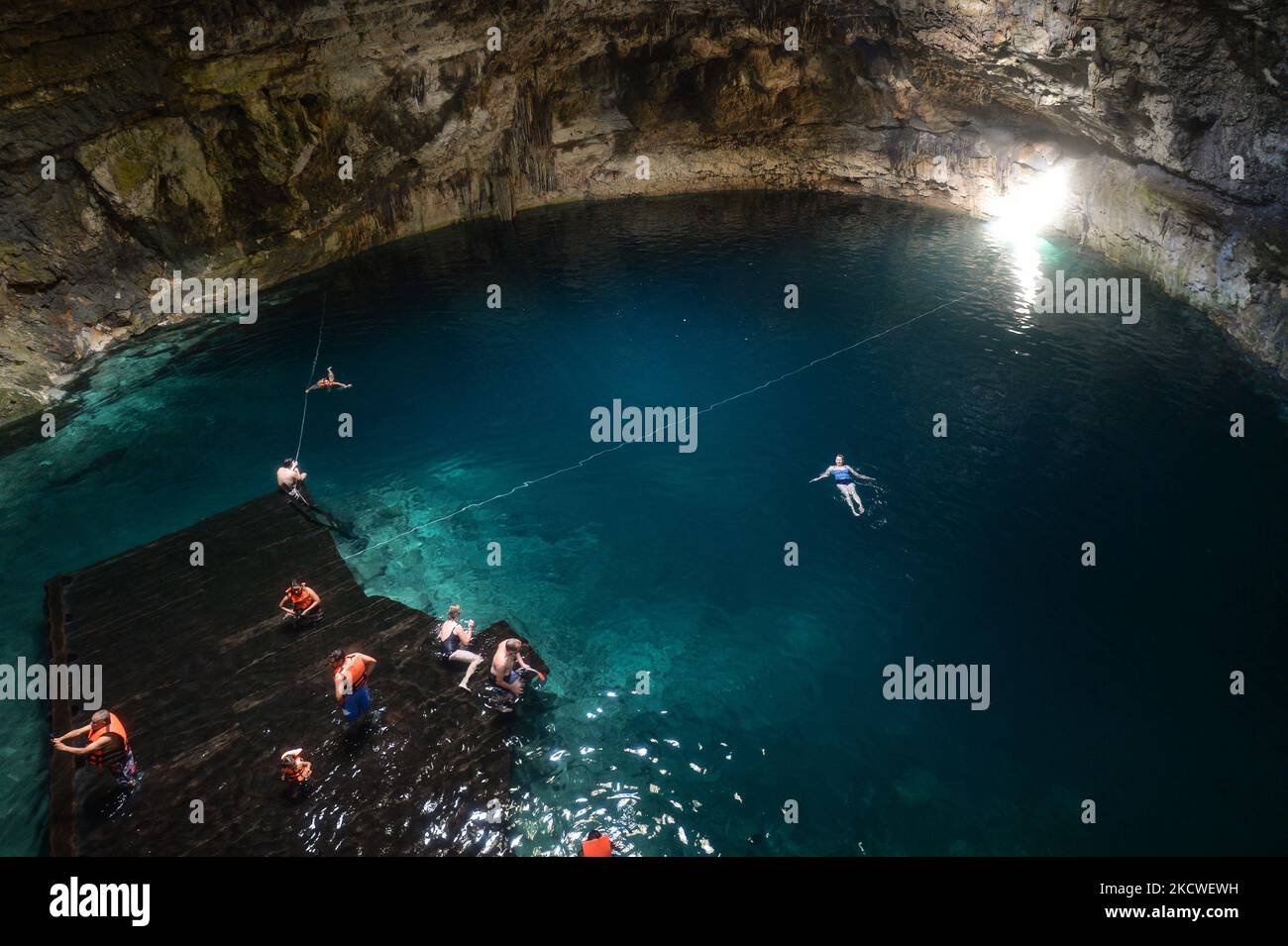 Visitors in Cenote X'ux Ha, an underground cave surrounded by ...