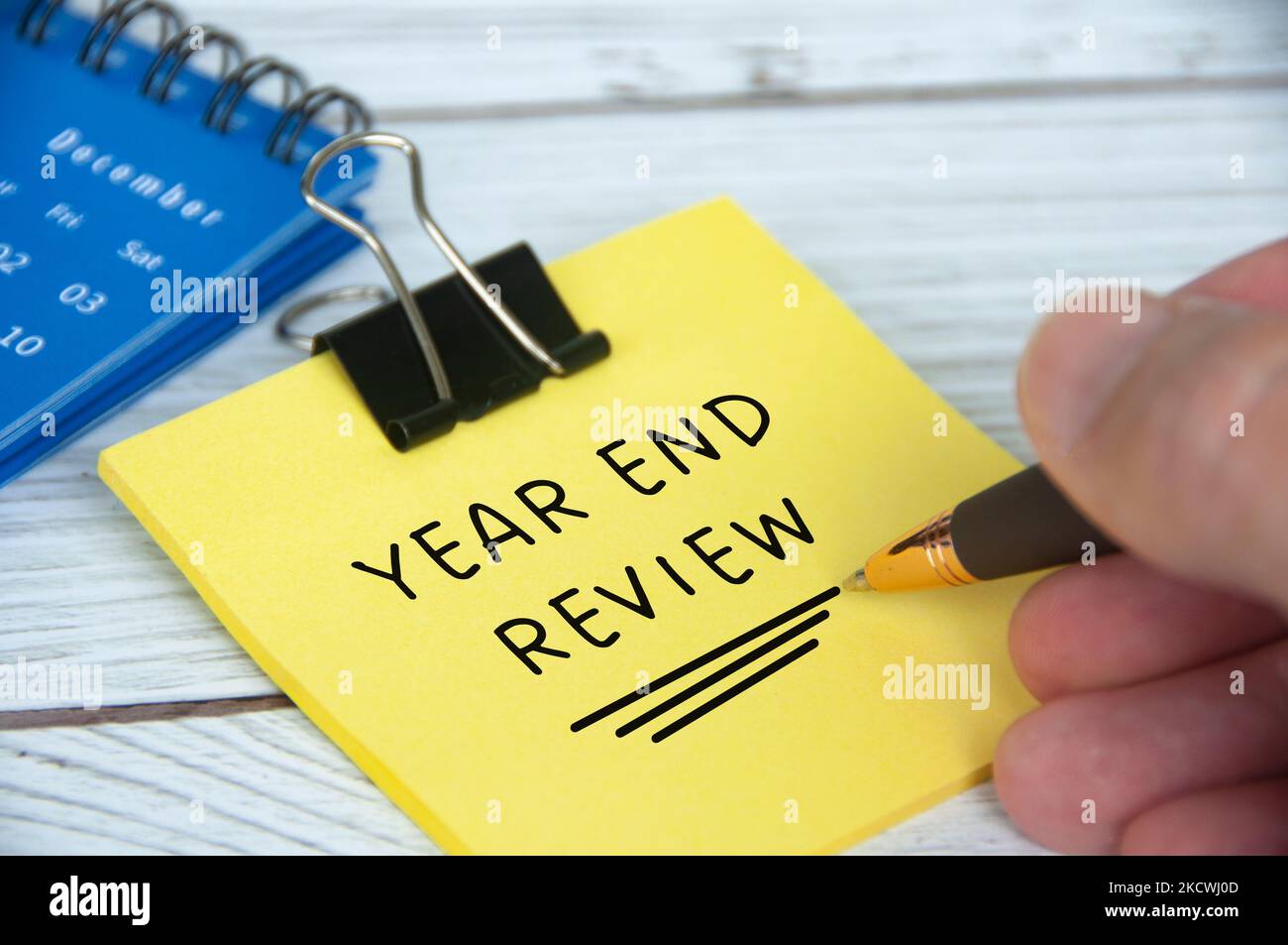 Year end review text on yellow notepad with December calendar ...