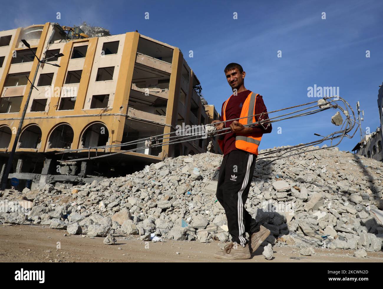 Palestinian workers clear the rubble of al-Jawhara Tower in Gaza City's ...