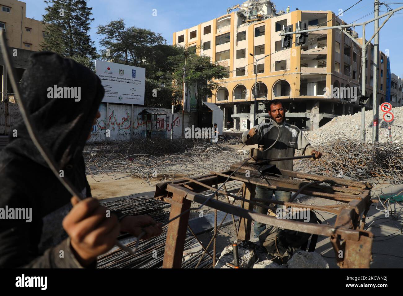 Palestinian workers clear the rubble of al-Jawhara Tower in Gaza City's ...