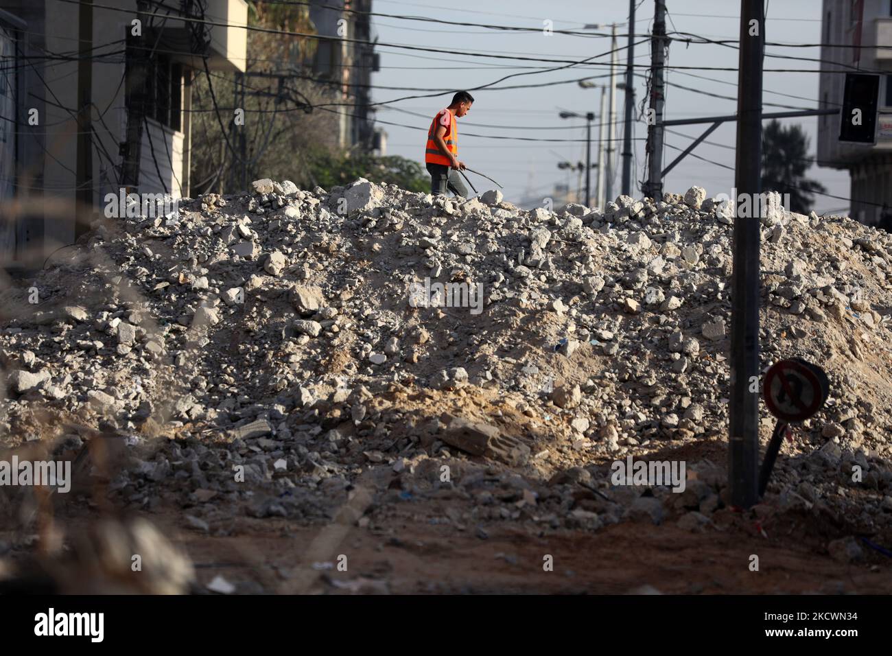 Palestinian workers clear the rubble of al-Jawhara Tower in Gaza City's ...
