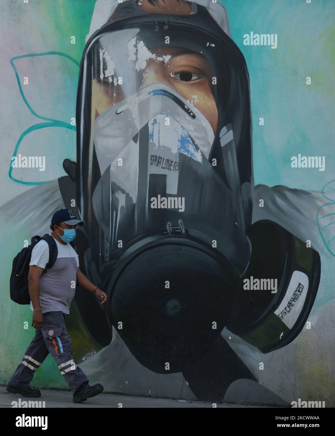 A man cycles past a mural portraying the Covid-19 first responders ...