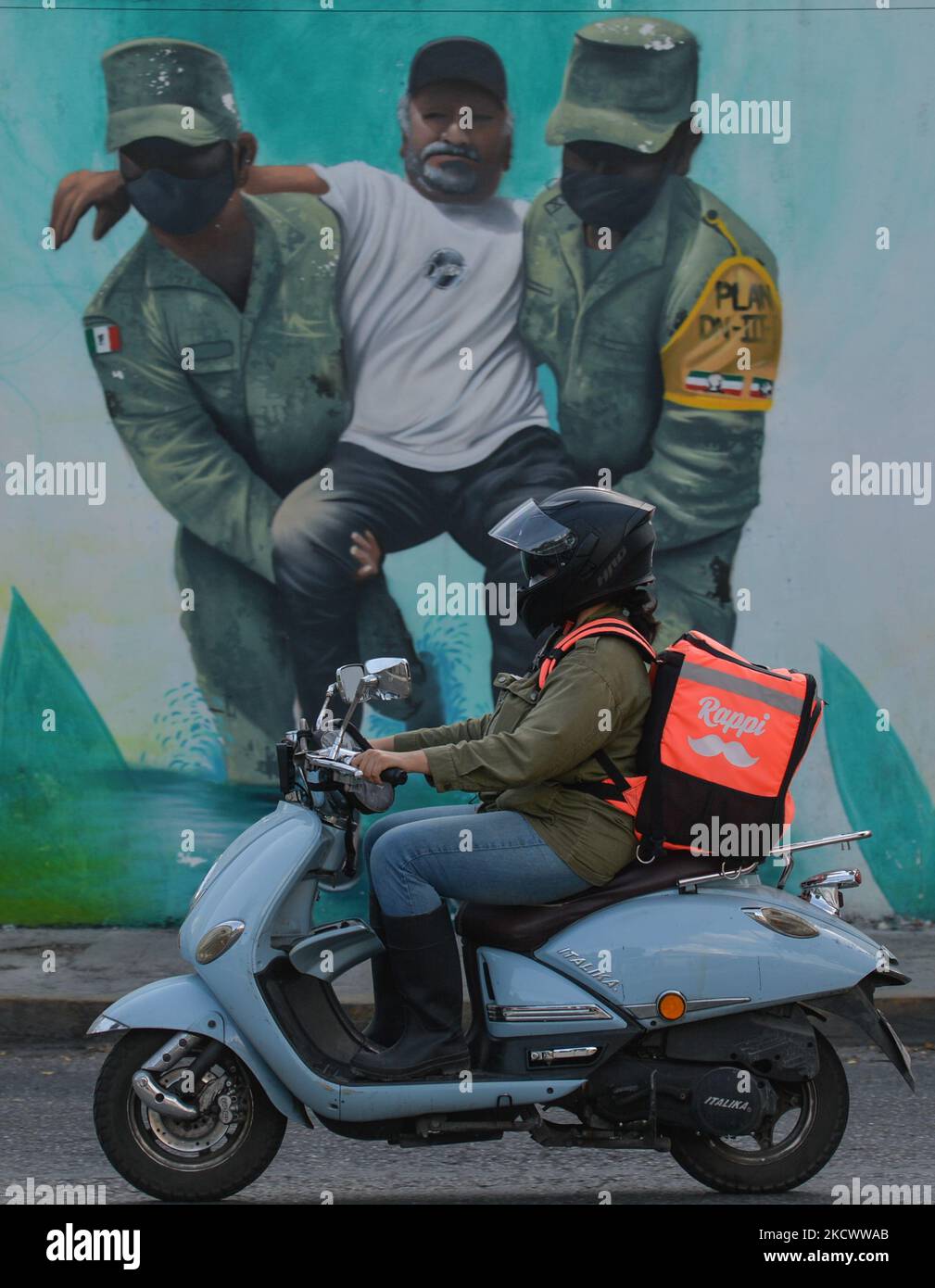 Rappi courier drives past a mural portraying the Covid-19 first ...