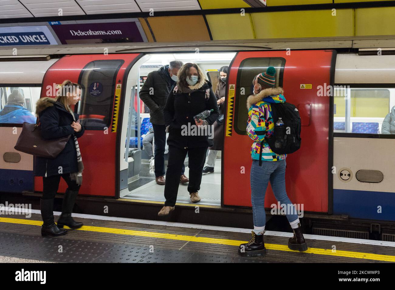 LONDON, UNITED KINGDOM - NOVEMBER 29, 2021: Commuters, some wearing ...