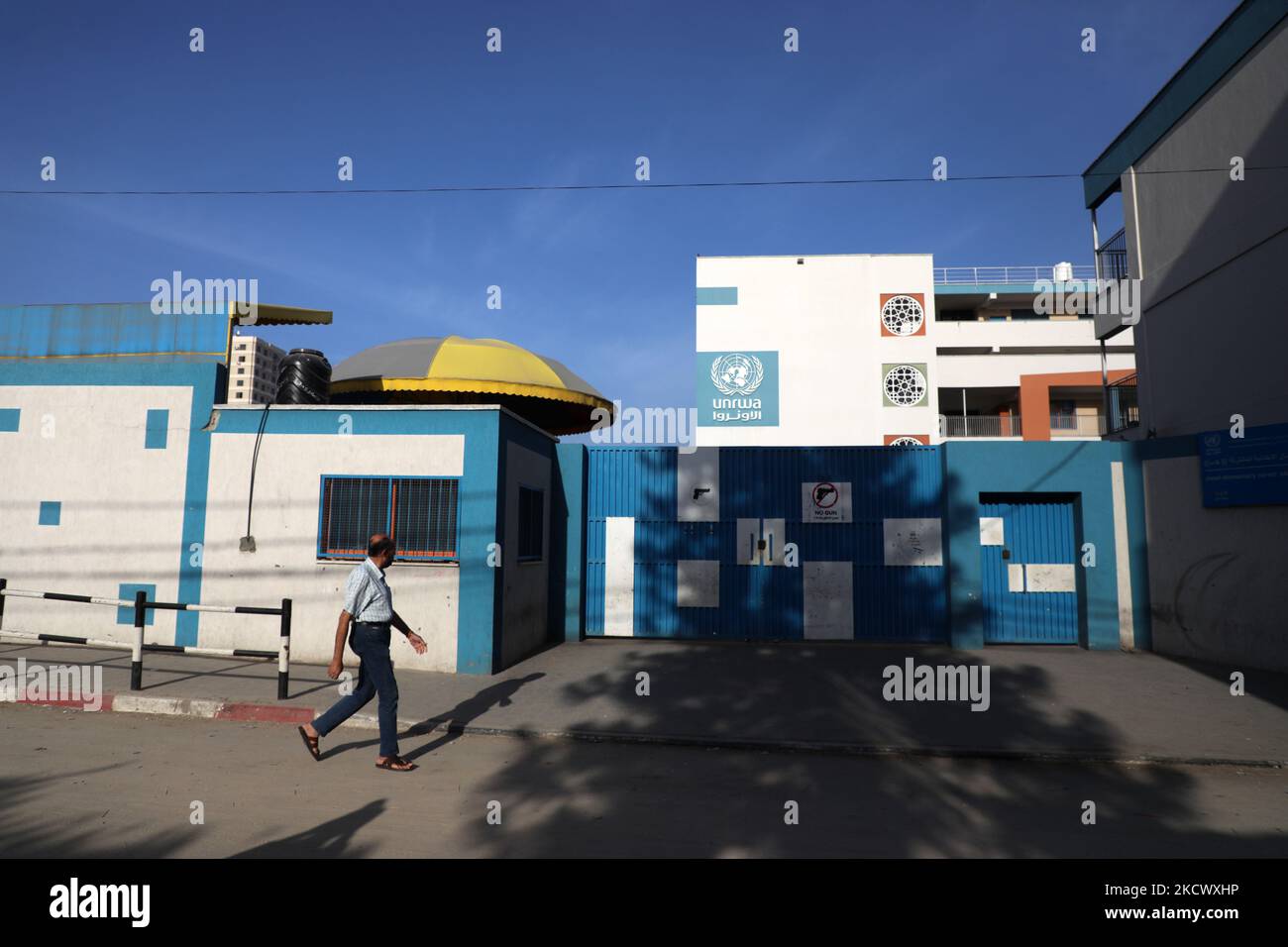 A Palestinian man walks past the shuttered headquarters of the United ...