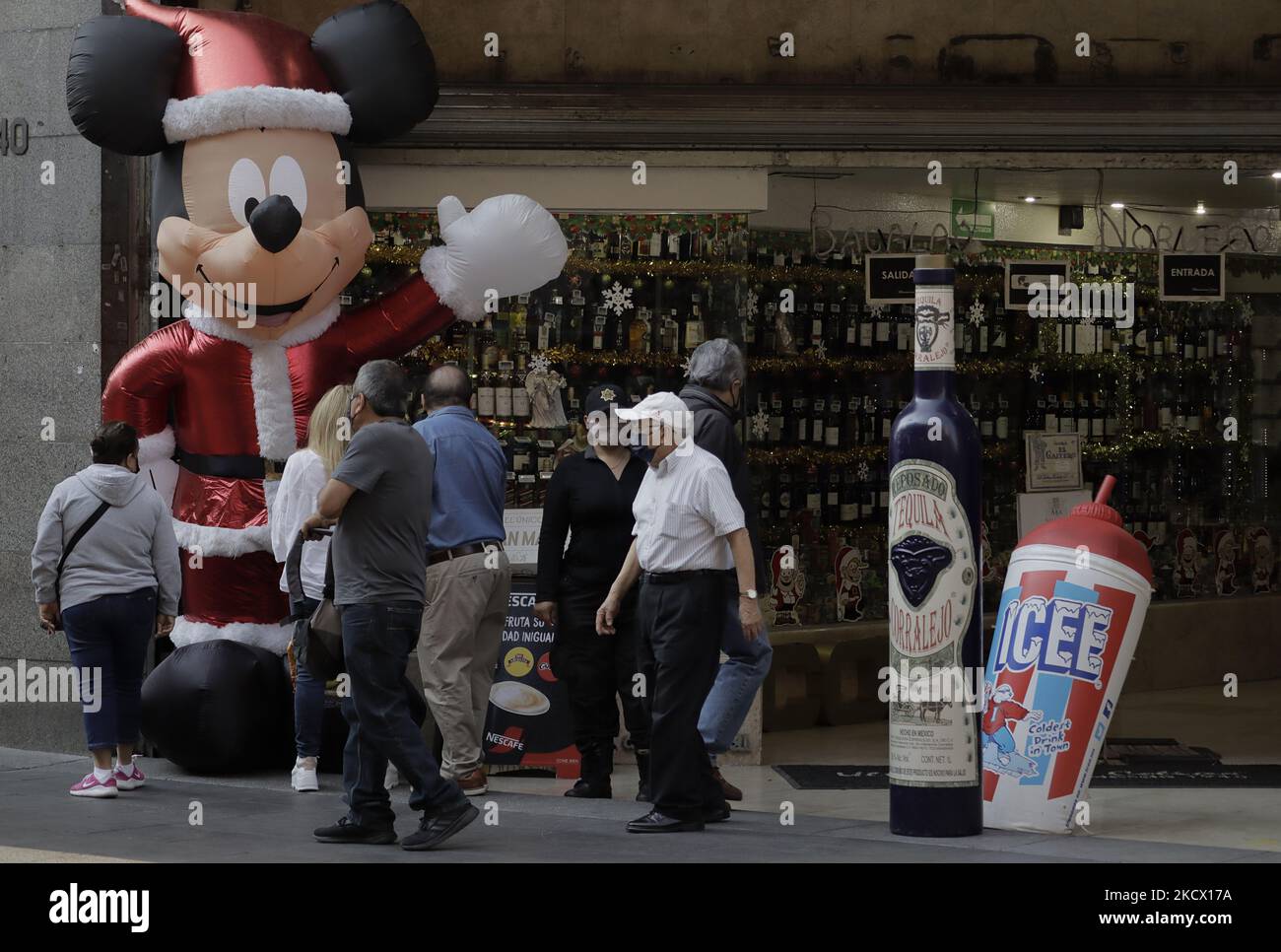 A group of people look at a Mickey Mouse figure in the Historic Centre ...