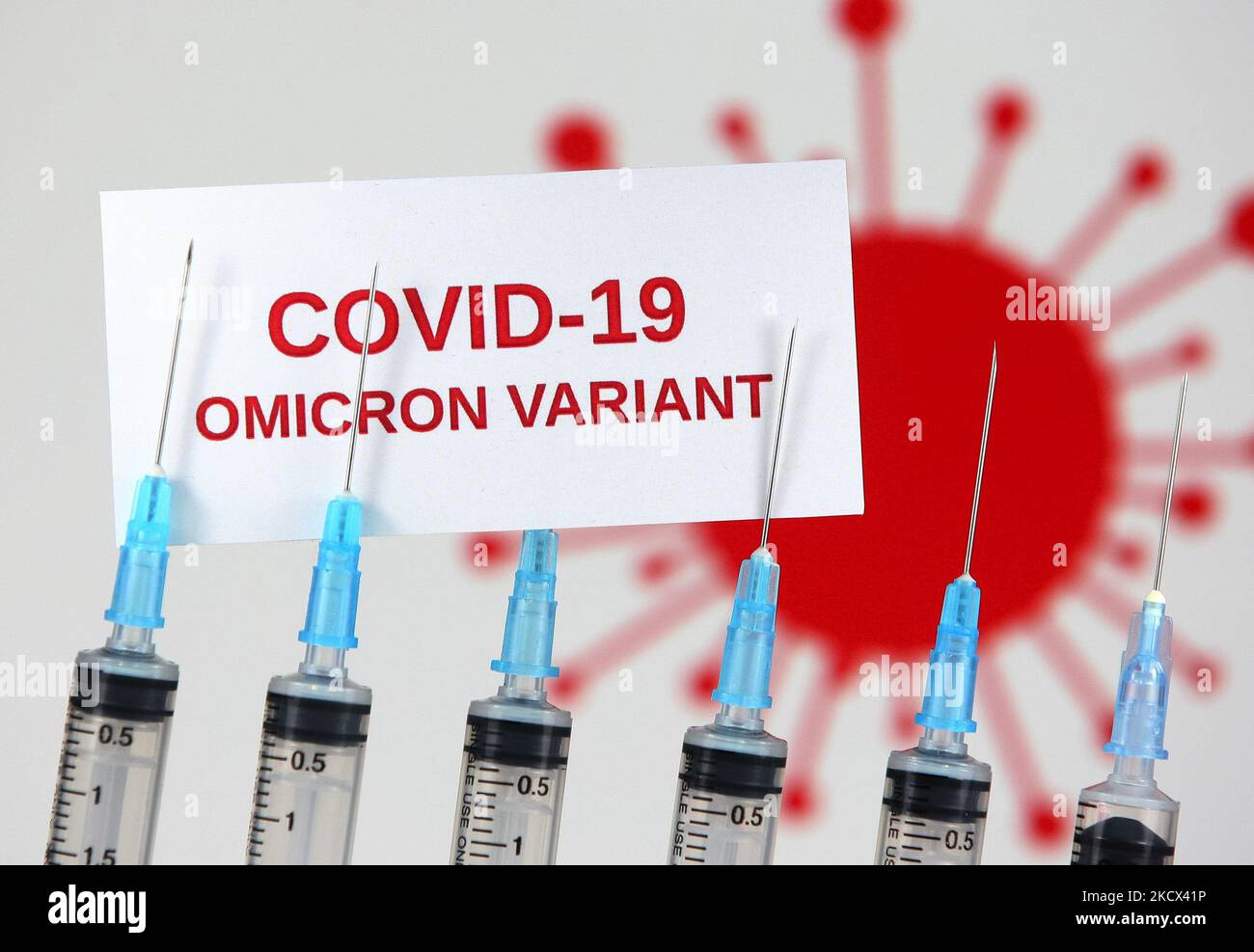 Syringes and a piece of a paper with words 'COVID-19 Omicron variant ...