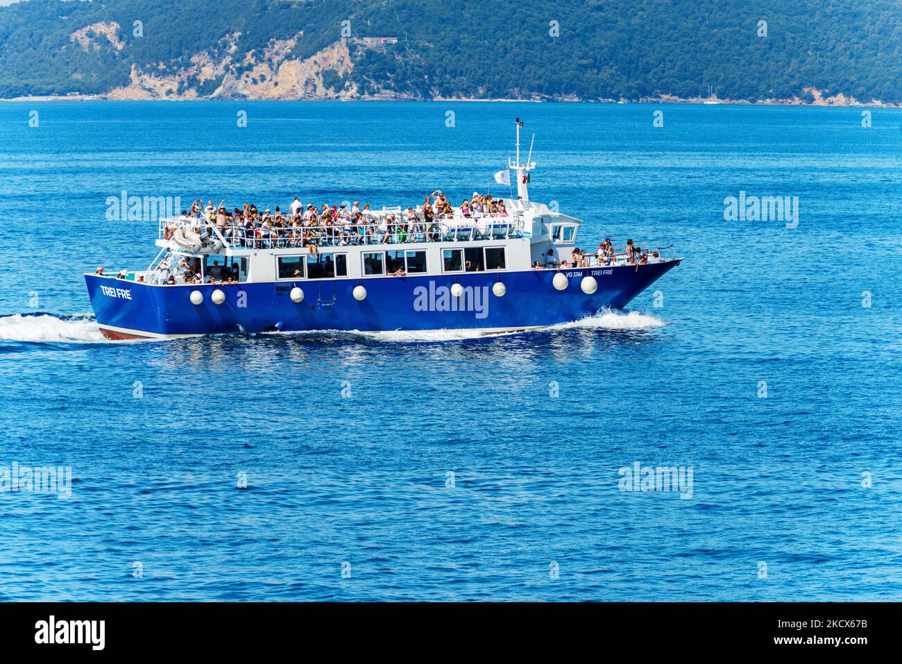 Blue ferry or tour boat crowded with tourists in motion in the Gulf of ...