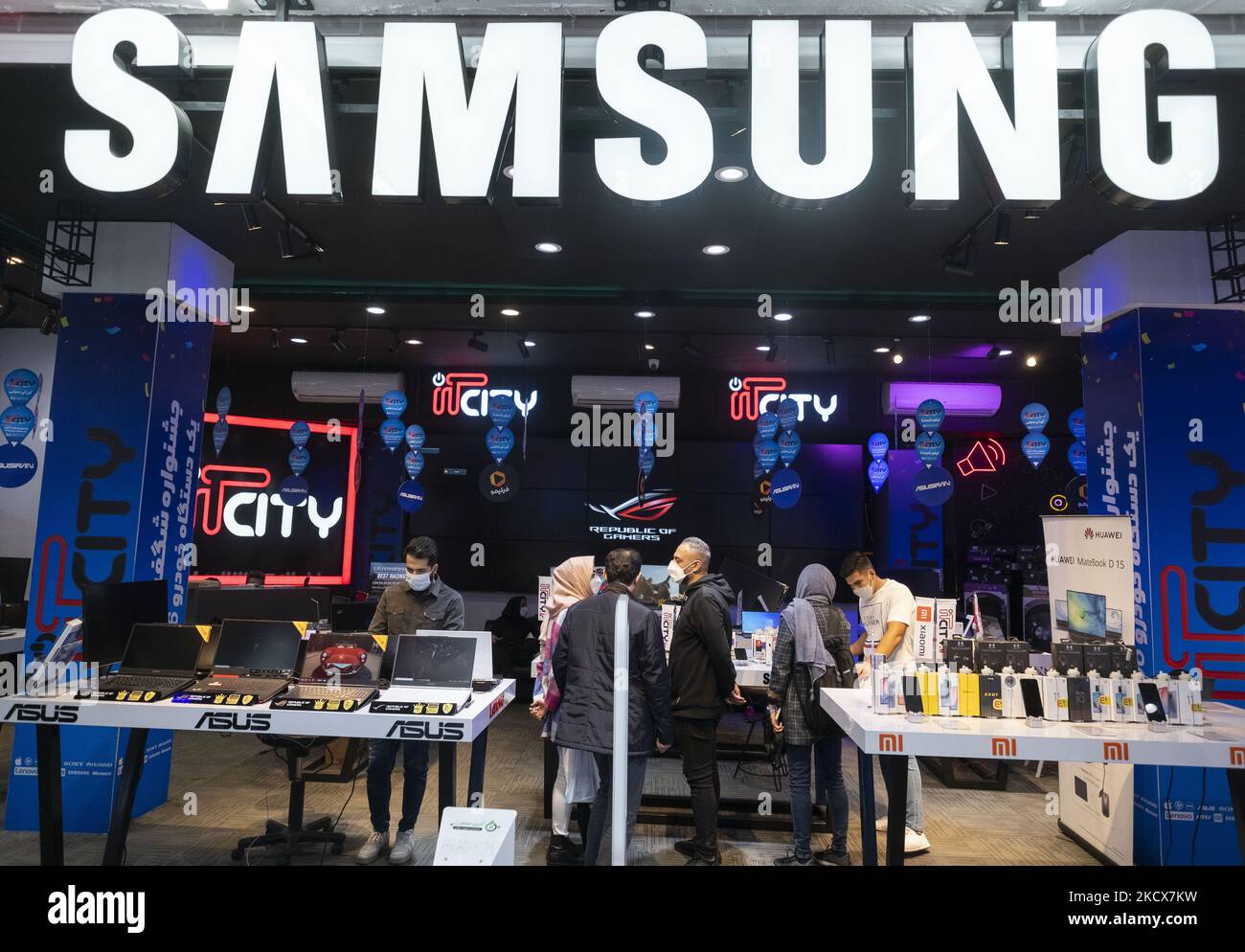 An Iranian salesman (R) speaks with his clients as they stand under a ...