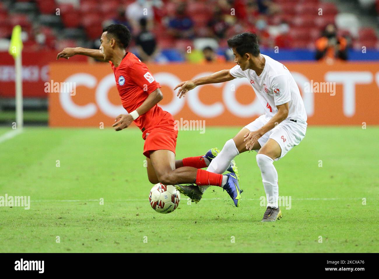 David Htan of Myanmar tackles Faris Ramli of Singapore during the AFF ...