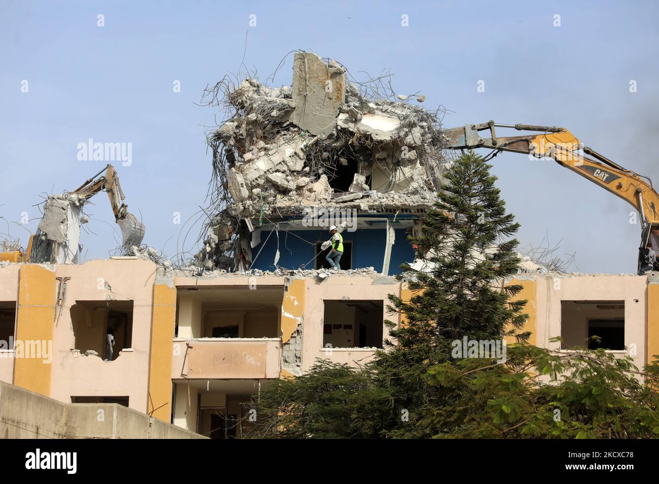 Palestinian workers clear the rubble of al-Jawhara Tower in Gaza City's ...