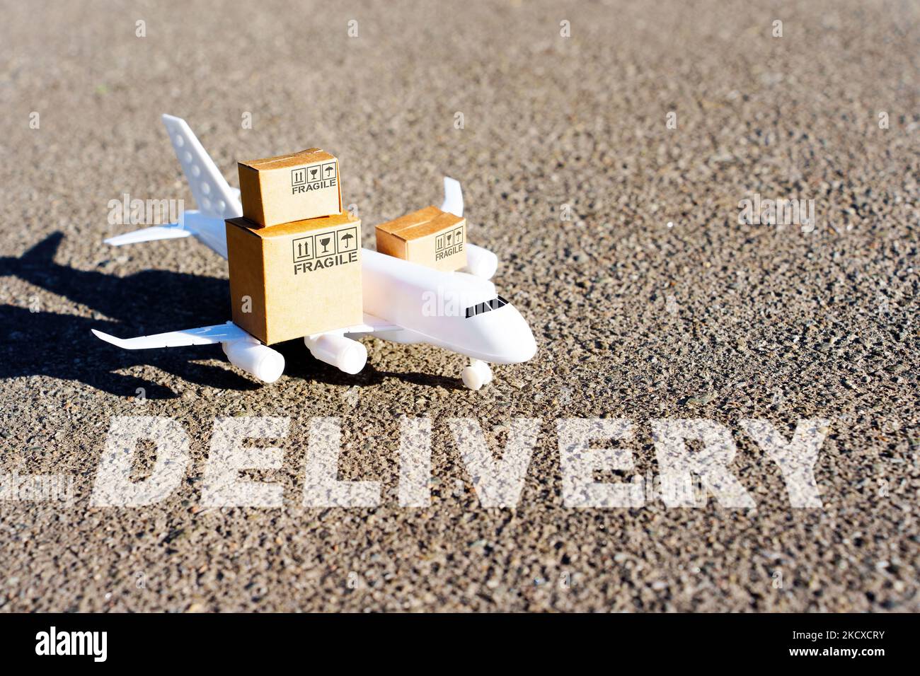 Tiny shipping boxes placed on a toy aircraft parked on the runway ...