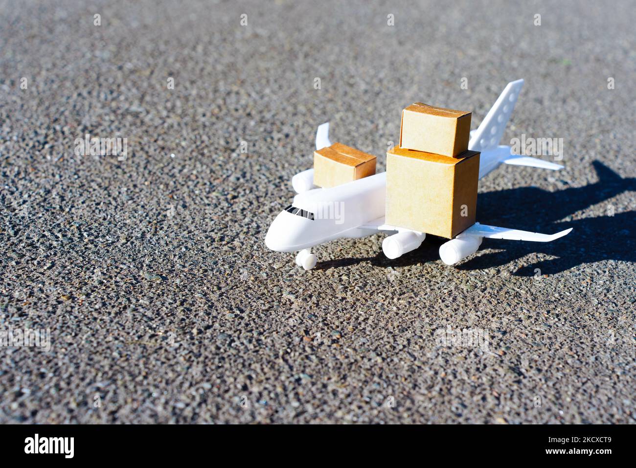 Toy airplane and tiny delivery boxes placed on the road outdoors Stock ...