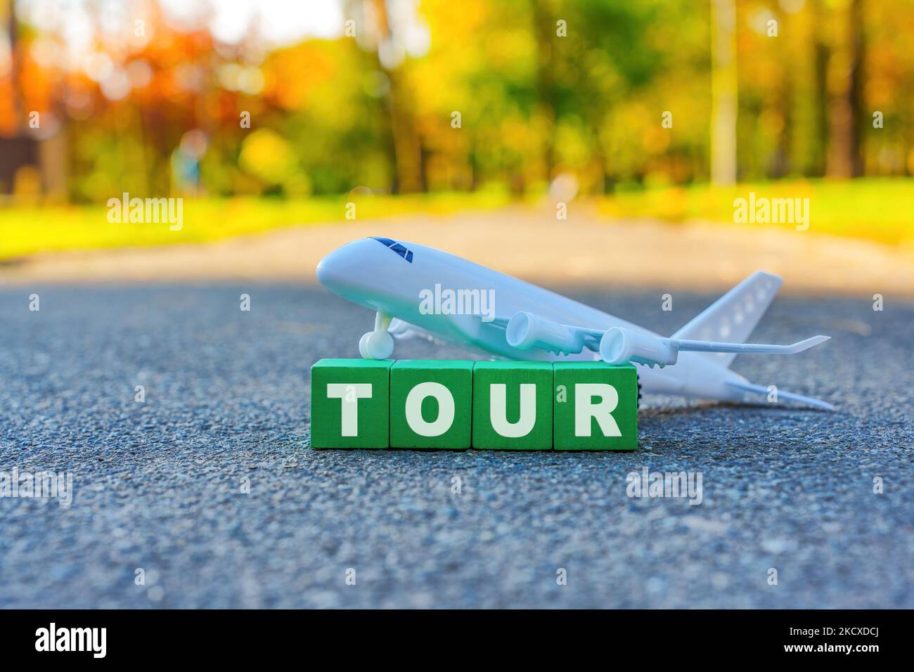 Word TOUR made from wooden alphabet blocks placed in front of a toy ...