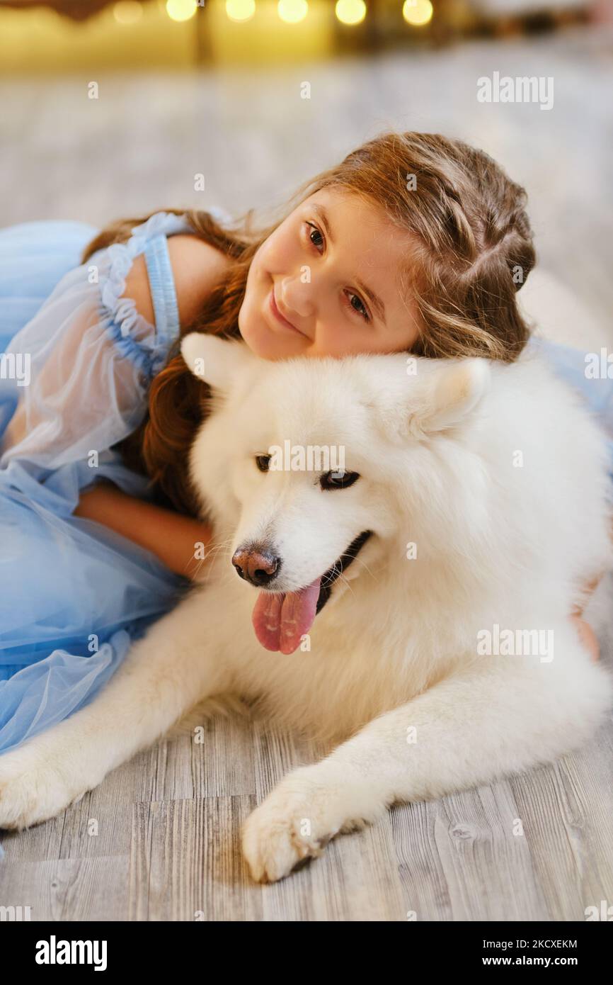 Nice girl in a light blue dress with white Samoyed dog Stock Photo - Alamy