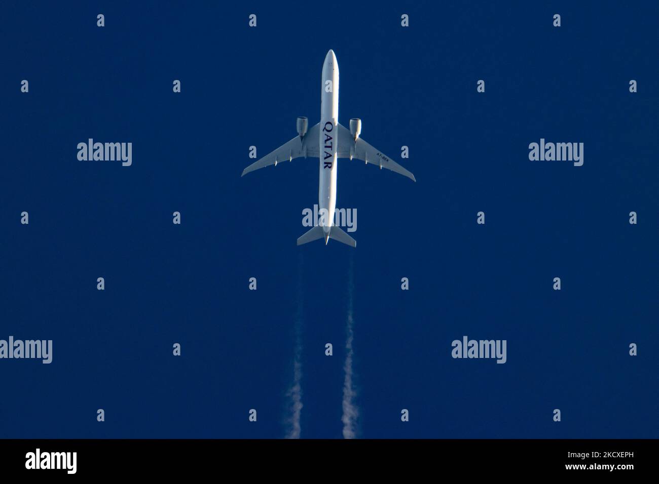 Qatar Airways Boeing 777-300ER overfly at 30.000 feet in the blue sky ...