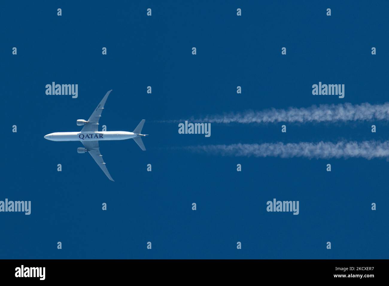 Qatar Airways Boeing 777-300ER overfly at 30.000 feet in the blue sky ...