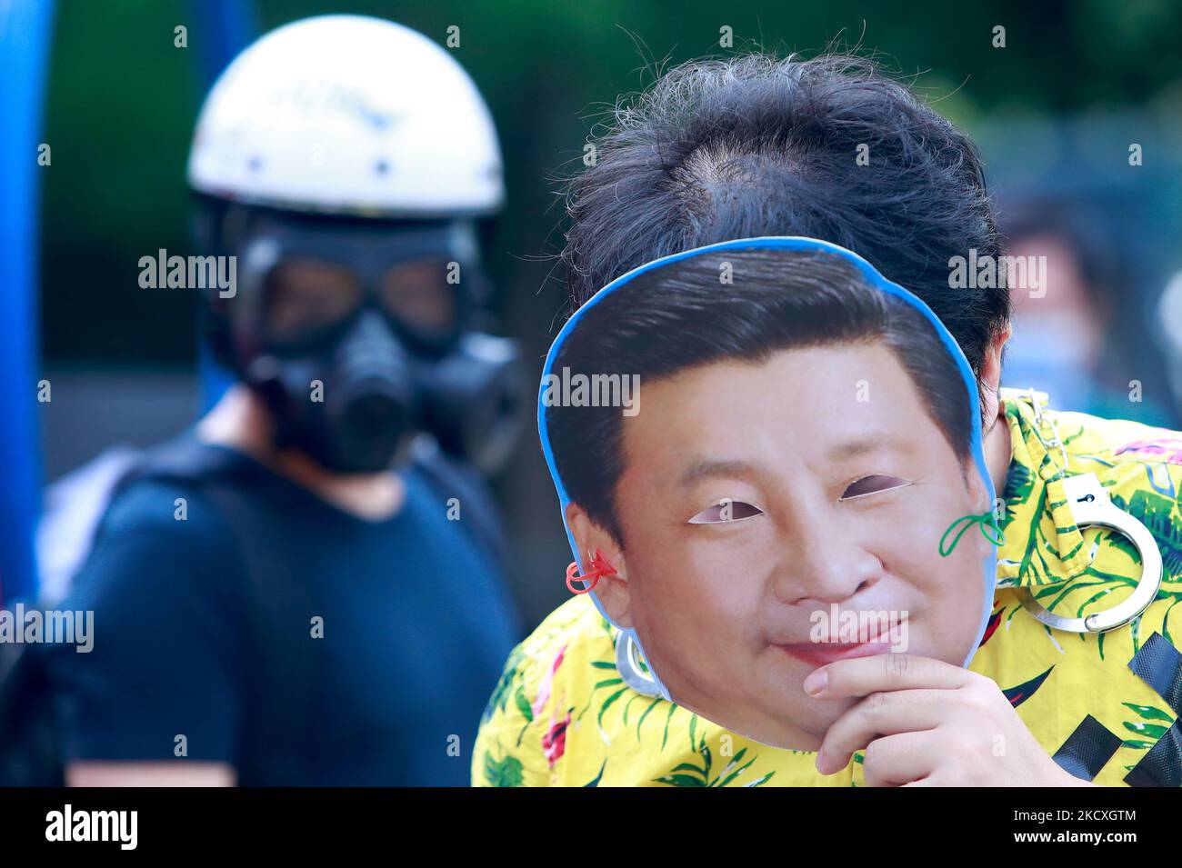 A protester wearing a mask with the face of Chinese president Xi ...