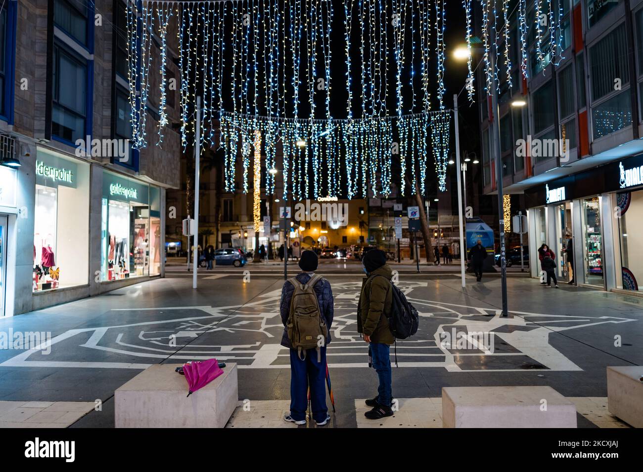 Two umbrella sellers await customers in the main shopping street Via ...